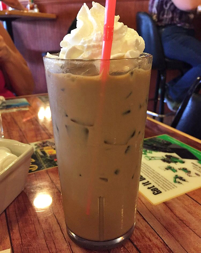 Iced coffee topped with a cloud of whipped cream &ndash; because sometimes adulting requires both caffeine and dessert simultaneously.
