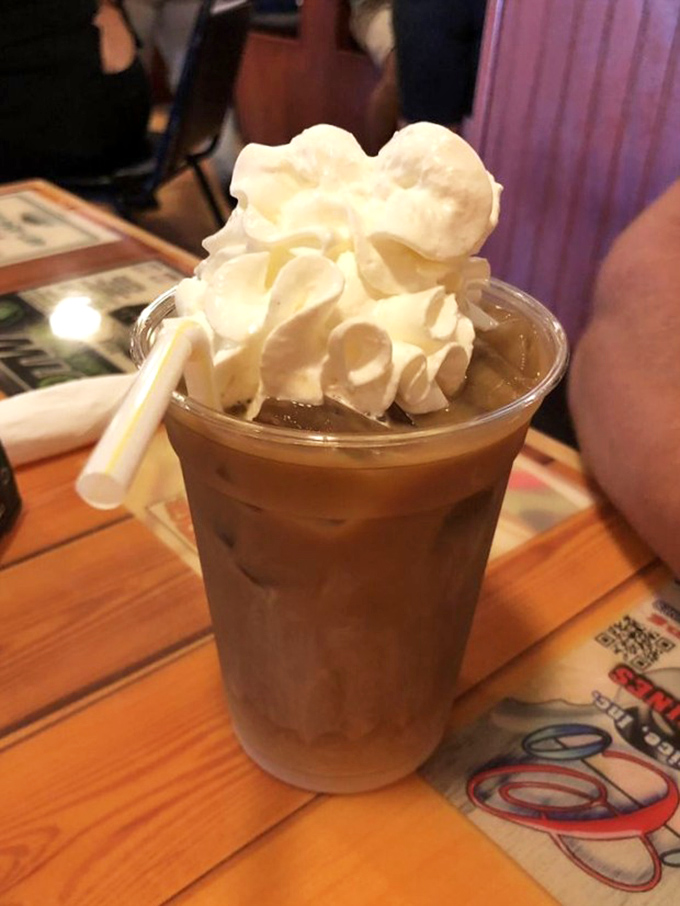 Iced coffee topped with whipped cream clouds - because sometimes you need dessert disguised as a beverage.