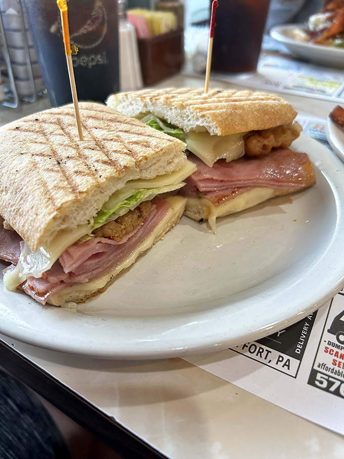 This sandwich isn't just stacked, it's architecturally sound&mdash;layers of deli meat, cheese, and veggies held together by toothpick engineering.