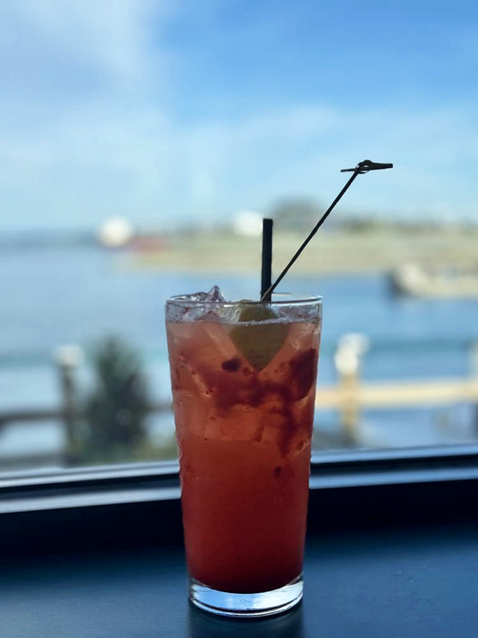 A sunset-colored cocktail with the perfect waterfront backdrop—nature's way of saying "you've made an excellent beverage choice today."