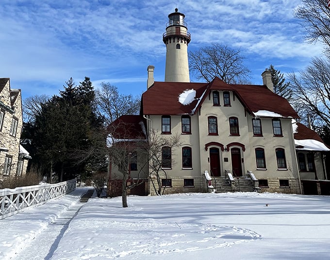 Winter transforms the lighthouse into a snow globe come to life, the red roof popping against the pristine white landscape.
