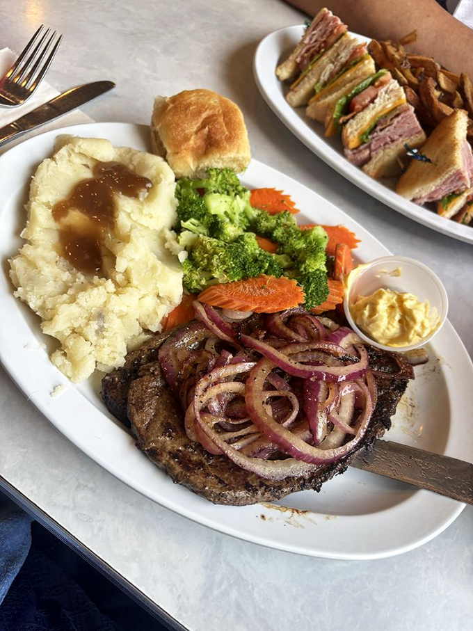 A plate that tells a story of comfort and tradition&mdash;tender steak topped with caramelized onions alongside mashed potatoes that could make a grown adult weep.