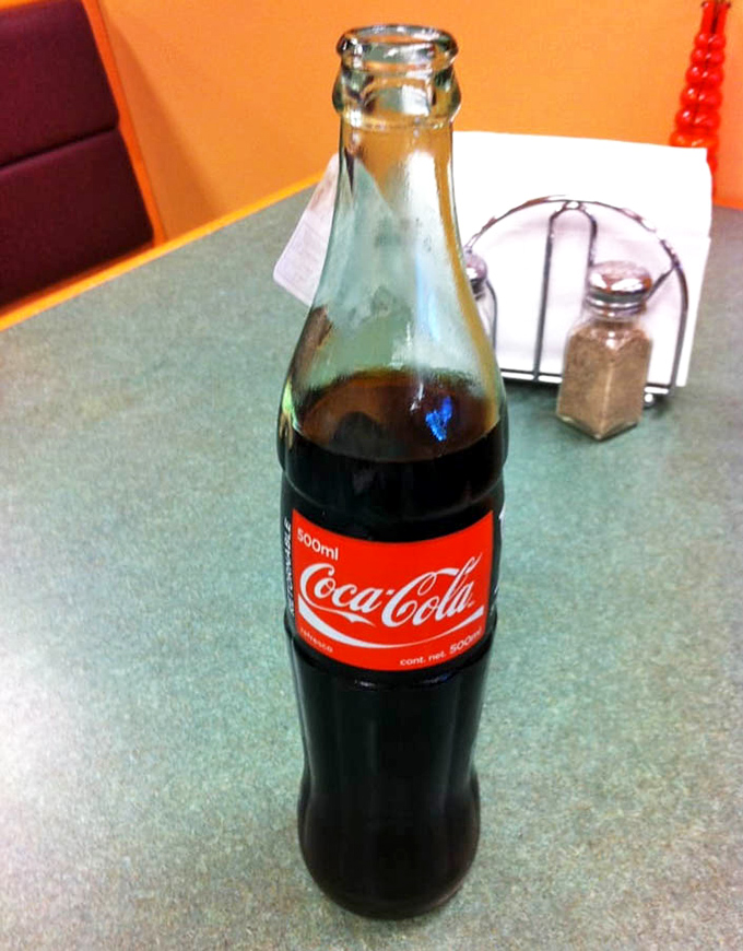 The Mexican Coke experience – glass bottle, real sugar, and that distinctive shape that somehow makes everything taste better. Nostalgia in liquid form.
