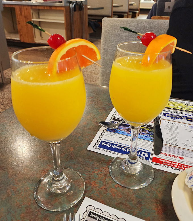 Weekend wisdom in liquid form &ndash; mimosas garnished with cherries and orange slices, because sometimes breakfast deserves a little sparkle.