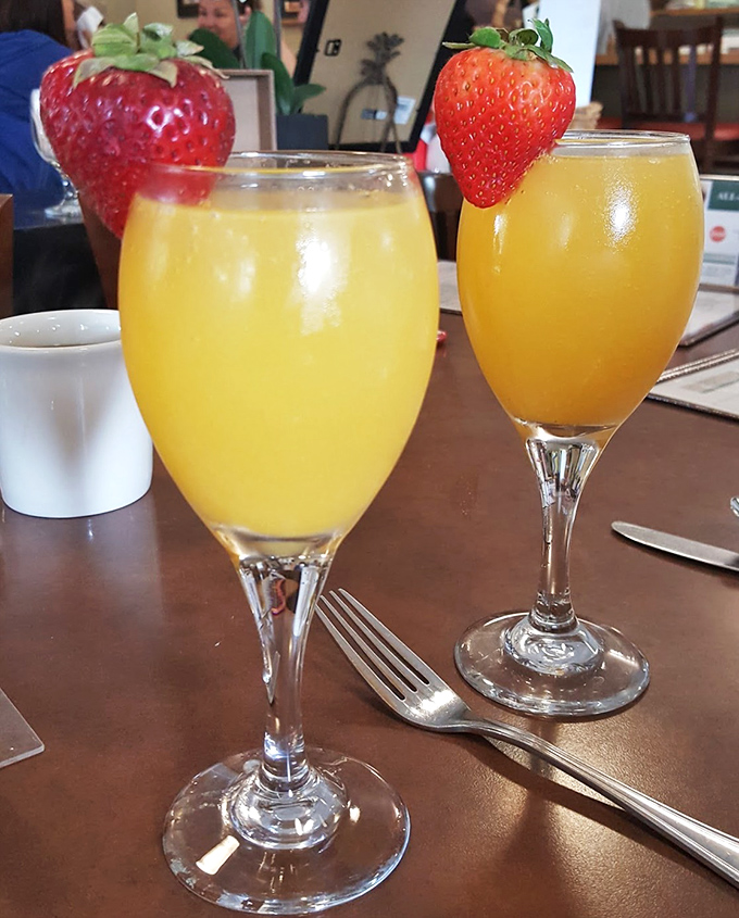 Mimosas garnished with fresh strawberries&mdash;because nothing says "today is special" like champagne before noon in elegant glassware.