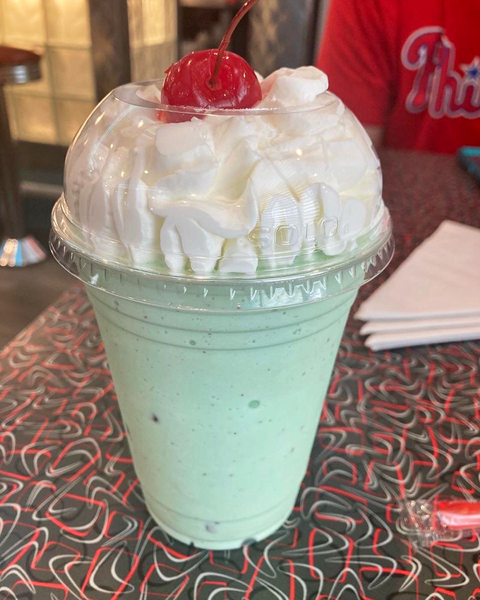 The mint chip shake arrives like a cool breeze on a summer day, topped with a cloud of whipped cream and that signature cherry beacon.