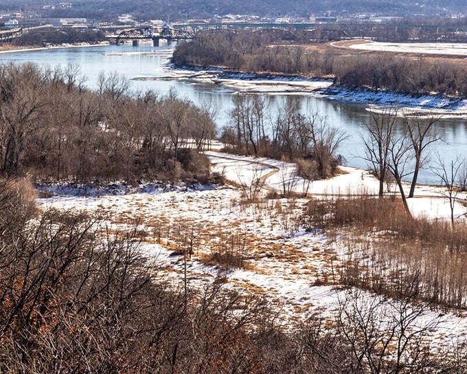 The Missouri River curves through the winter landscape like a silver ribbon, carrying centuries of stories downstream toward the Mississippi.