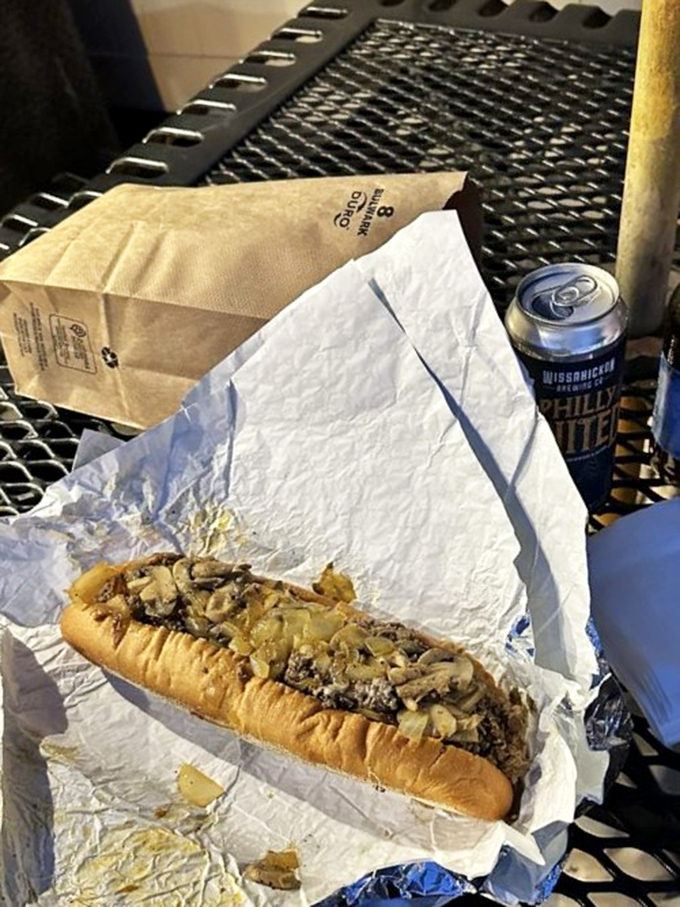 The paper-wrapped simplicity of outdoor dining with a perfectly crafted cheesesteak. Some of life's best meals happen on metal tables.
