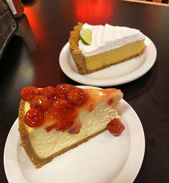 Cheesecake showdown: cherry-topped New York-style versus key lime with whipped cream. The only losing move is not ordering both.