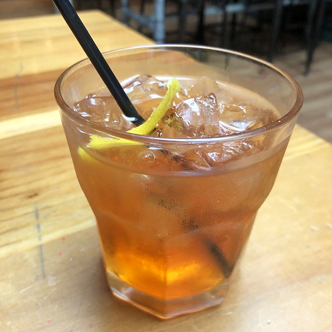 A well-crafted Old Fashioned with a citrus twist—because sometimes you need something stronger than conversation to wash down greatness.