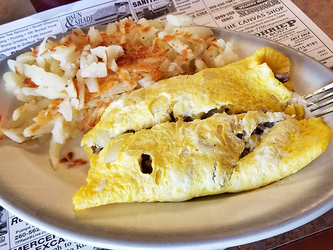 This omelet arrives like sunshine on a plate, proving breakfast can be both art and sustenance.