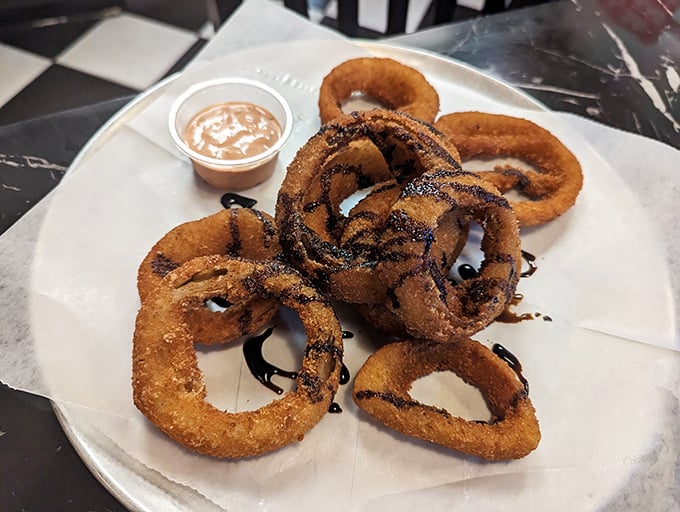 Onion rings drizzled with what appears to be balsamic reduction &ndash; because even side dishes deserve their moment in the spotlight.