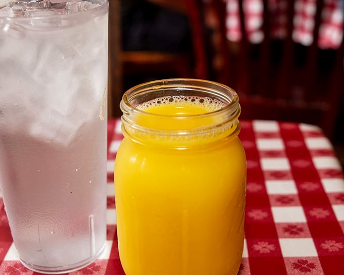 Mason jar of orange juice alongside ice water&mdash;because proper Southern hospitality means options for washing down those heavenly biscuits.