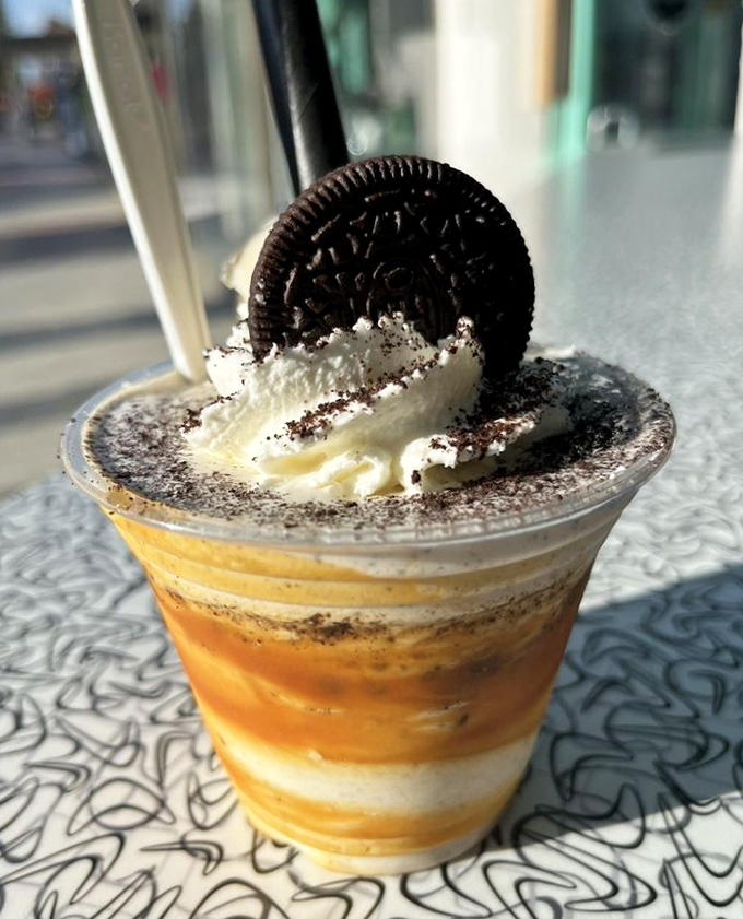 Cookie meets caramel in a cup of pure joy. This layered masterpiece with its Oreo crown is what happens when dessert has ambition.