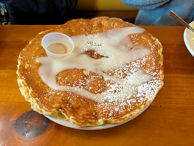 A pancake so massive it needs its own zip code, dusted with powdered sugar like Idaho's first snowfall.