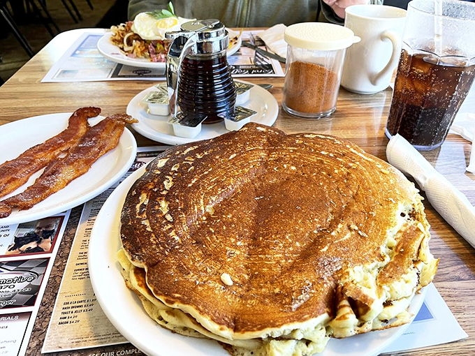 This pancake isn't just large &ndash; it's the size of your childhood dreams. The side of bacon is there for moral support.
