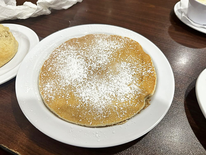 A pancake so perfectly golden it belongs in Fort Knox. One bite of this powdered sugar-dusted beauty and you'll forget about your "vacation diet" entirely.