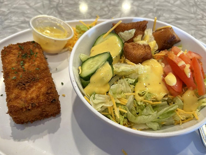 A study in contrasts: crispy breaded fish alongside a fresh garden salad. Like wearing a tuxedo with sneakers&mdash;unexpected but somehow just right.