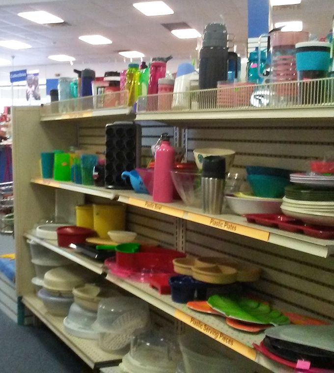 A rainbow of plastic kitchenware stands ready for adoption, proving that organization and affordability can peacefully coexist in the thrift world.