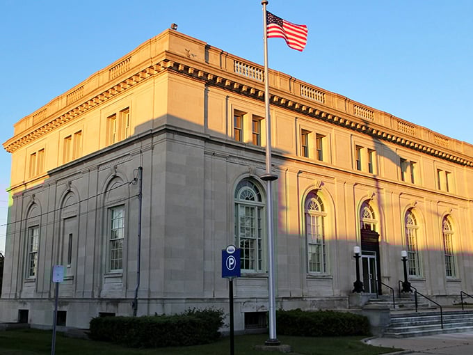 The historic Post Office building glows golden in evening light, a testament to an era when public architecture was designed to inspire civic pride.