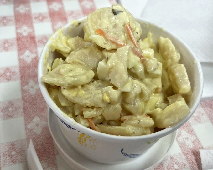 That potato salad sits pretty in its bowl, looking like grandma's recipe if grandma had a PhD in comfort food.