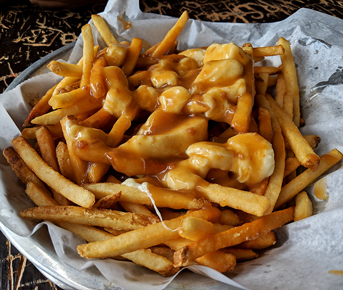 Poutine: where fries meet their destiny. This Canadian classic gets a Wisconsin makeover with a cascade of melty cheese that stretches with each bite.