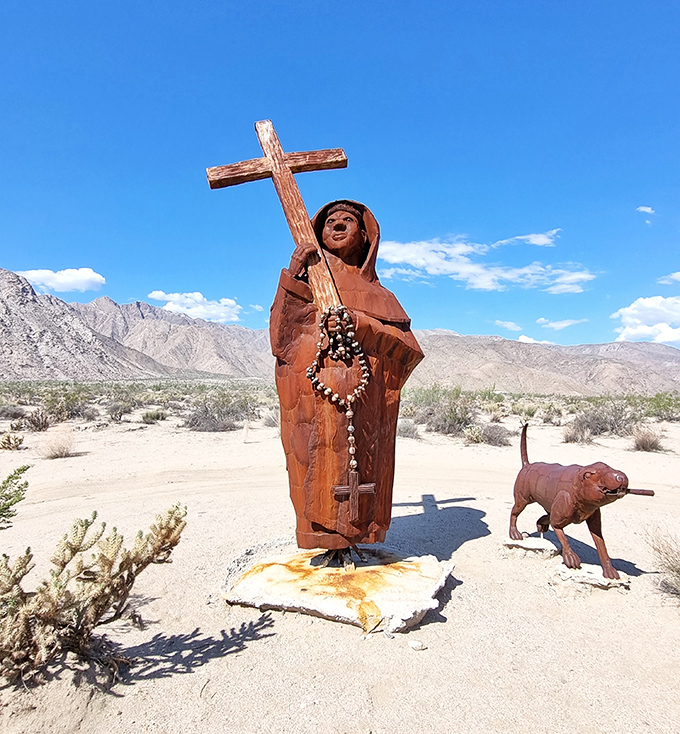 A holy figure and faithful companion stand watch over the desert, proving that even spiritual journeys need good walking shoes.
