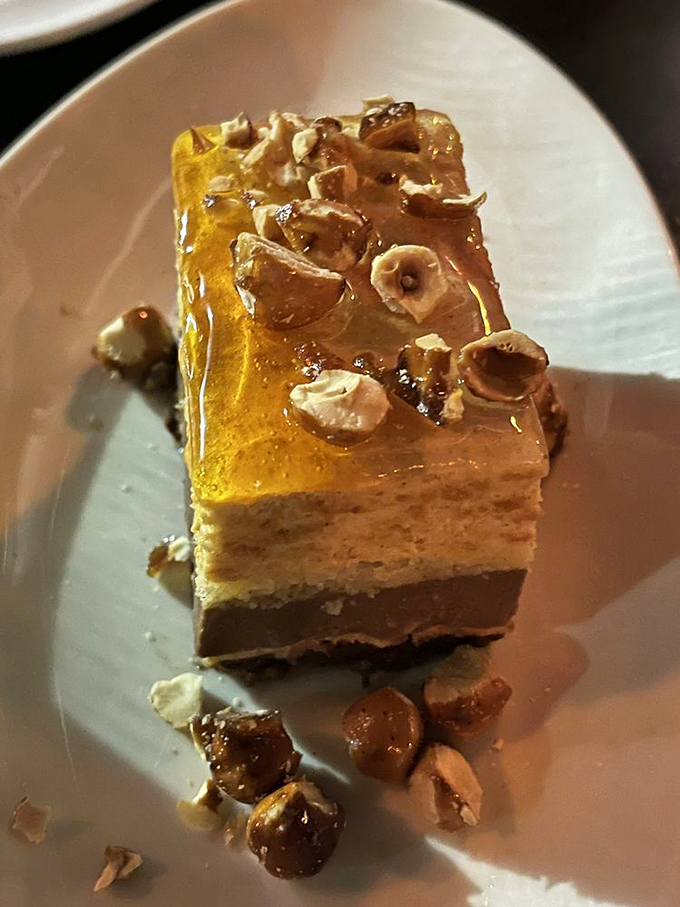 Dessert architecture at its finest &ndash; layers of flavor topped with what appears to be edible sunshine and hazelnut confetti.