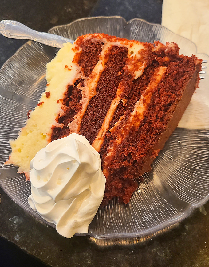 Red velvet cake with layers that could tell stories. That cream cheese frosting boundary between each crimson tier is where happiness lives permanently. 