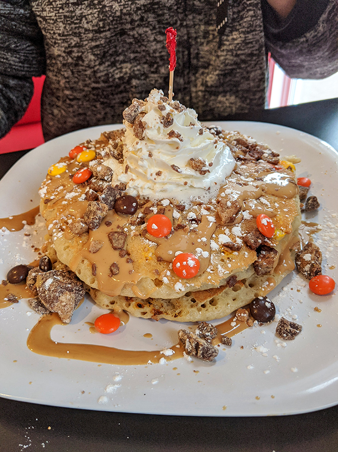 Pancakes that could double as a birthday cake! Topped with whipped cream, candy, and what appears to be every delicious thing in the pantry.