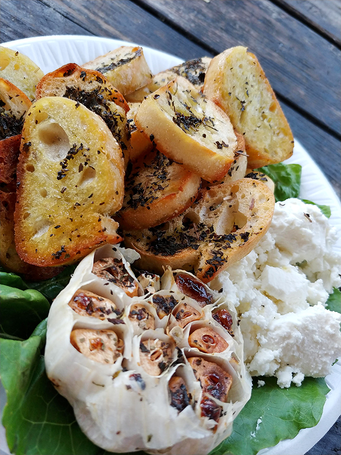 Garlic roasted to sweet submission, crusty bread, and creamy goat cheese—proof that simple ingredients handled with respect create culinary poetry.