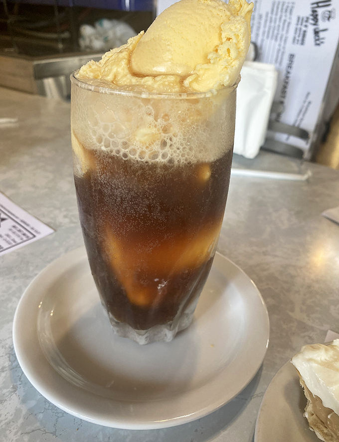 The root beer float arrives like a science experiment gone deliciously right—ice cream slowly surrendering to soda in a glass of nostalgic perfection.