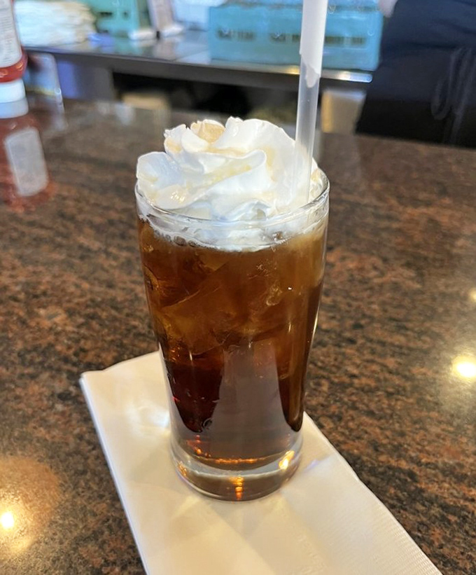 Root beer float topped with whipped cream clouds &ndash; childhood nostalgia served in a perfect glass.