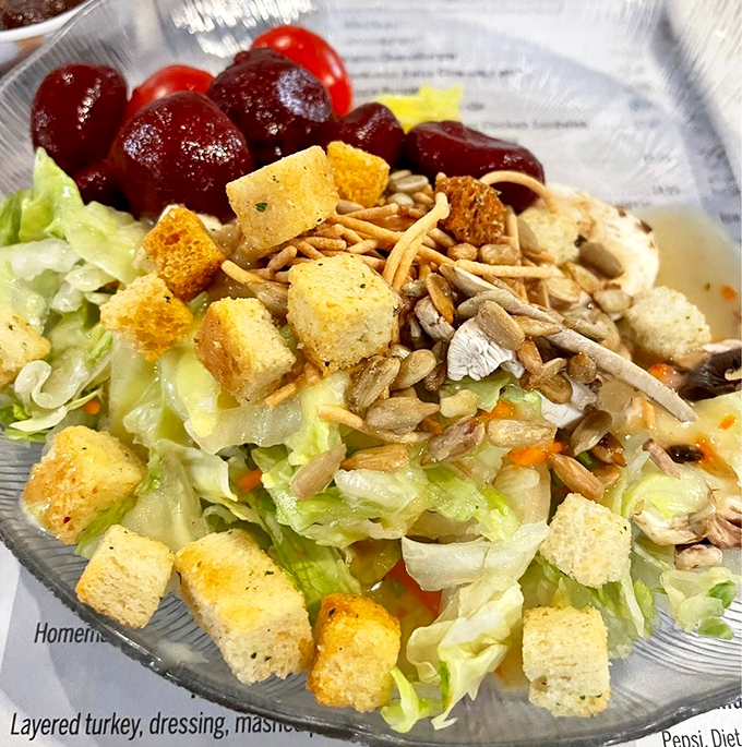 A salad that actually deserves respect—crisp lettuce, sunflower seeds, and those croutons that crunch like they mean business.