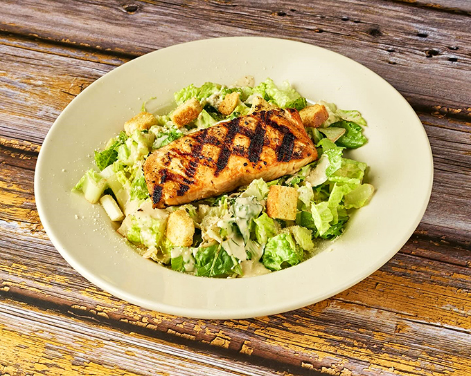 Caesar salad gets the royal treatment with perfectly grilled salmon that would make any pescatarian sing "God Save the Queen."