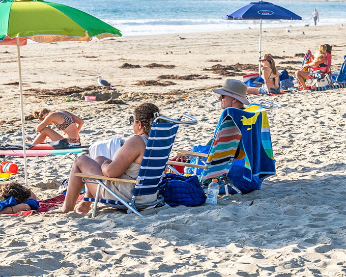 Beach day perfection: colorful umbrellas dot the sand as visitors embrace the timeless art of doing absolutely nothing beside the Pacific.