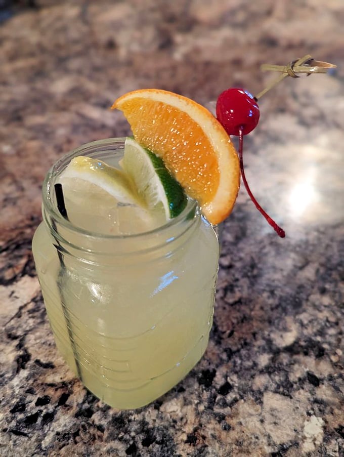 A mason jar margarita garnished with citrus and cherry—because sometimes the best cocktails don't need crystal stemware to transport you to your happy place.