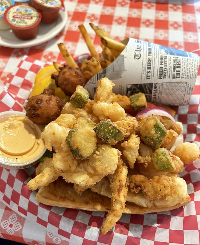 Fried seafood perfection: golden nuggets of seafood and zucchini with crispy fries served in a newspaper cone—nostalgia and deliciousness in equal measure.