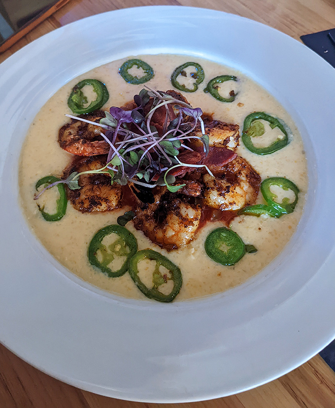 Shrimp and grits reimagined with artistic flair&mdash;those jalape&ntilde;o rings create a spicy halo around perfectly seasoned seafood. Southern comfort meets Columbus creativity.