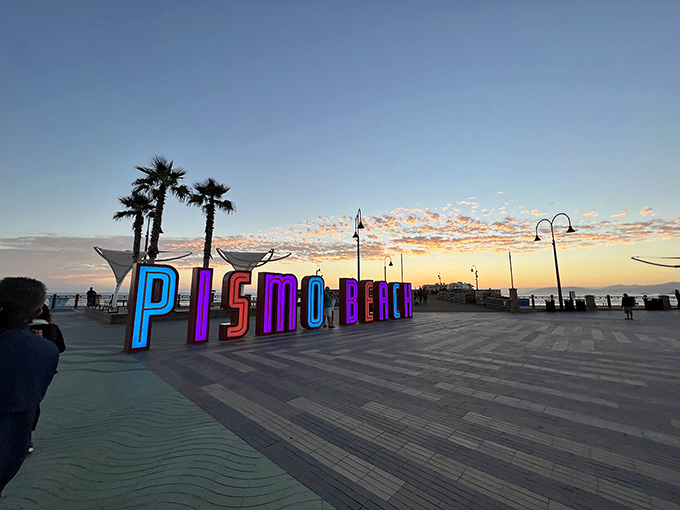 Pismo Beach's colorful sign glows at dusk, reminding shoppers there's more to life than bargains&mdash;though the bargains are pretty spectacular.