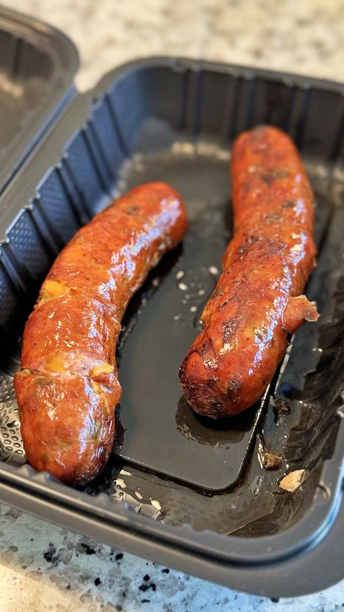 These smoked sausages glisten with promise, their plump exteriors barely containing the juicy, spiced meat within. The perfect handheld barbecue experience.