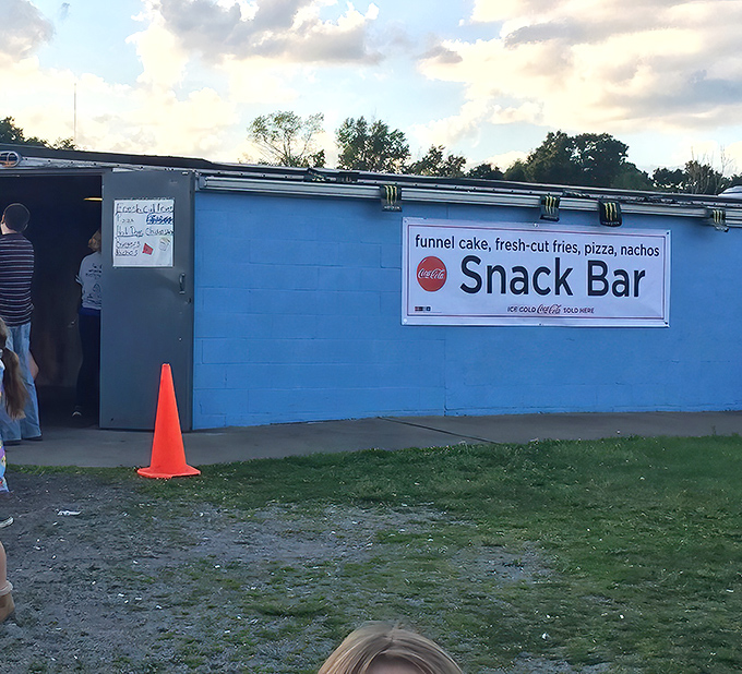 The snack bar's blue exterior promises simple pleasures: funnel cake, fresh-cut fries, and zero pretentious menu items with unpronounceable ingredients.