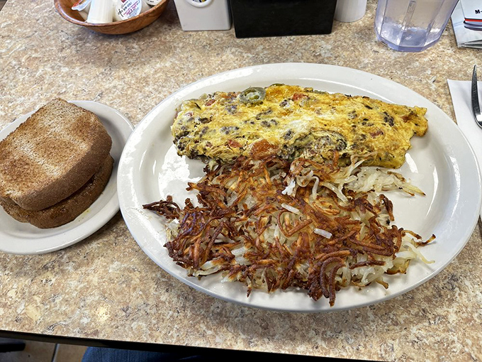 An omelet that's achieved that perfect fluff-to-filling ratio, paired with hash browns that have clearly been introduced to proper seasoning.