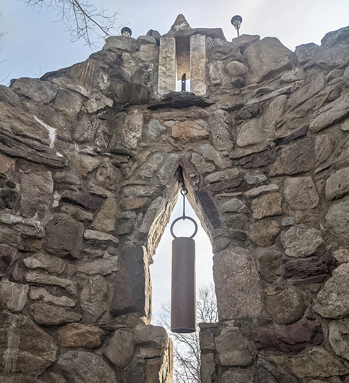 Ancient stonework frames a hanging bell, waiting for the wind's touch. Silent most days, it speaks volumes about the craftsmanship of another era.