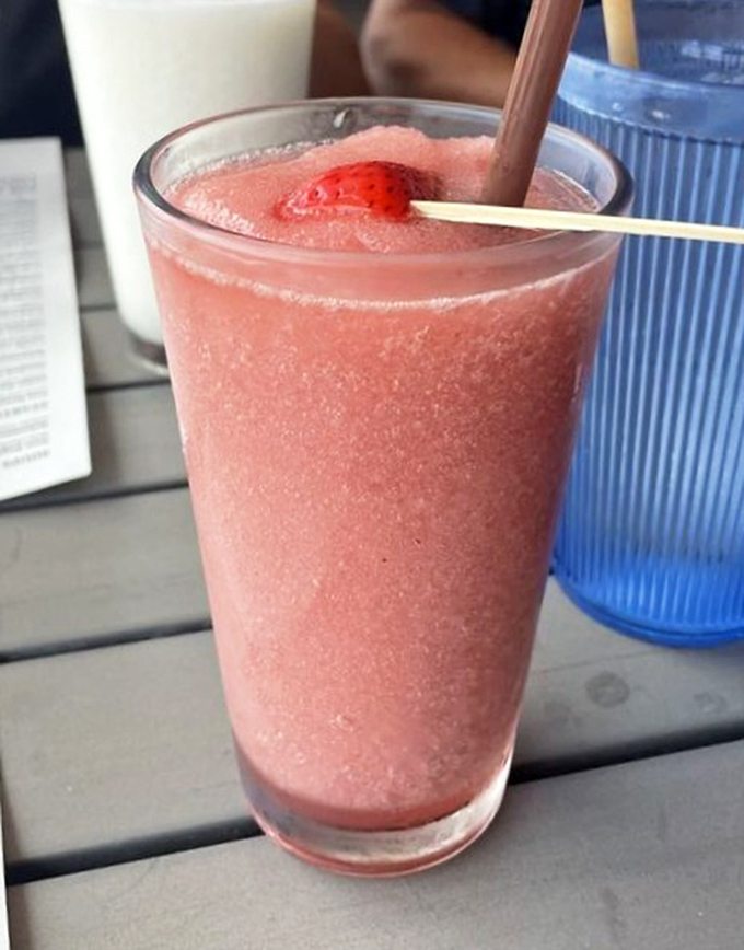 A strawberry daiquiri that looks like summer decided to throw a party in a glass. That strawberry garnish is just showing off.