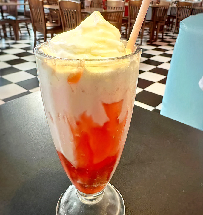 This strawberry milkshake isn't just a drink—it's dessert in a glass, wearing a cloud of whipped cream like it's dressed for the prom.