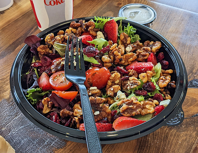 A salad that doesn't apologize for being healthy &ndash; crisp greens, juicy strawberries, and candied walnuts creating the perfect counterpoint to all that fried goodness.