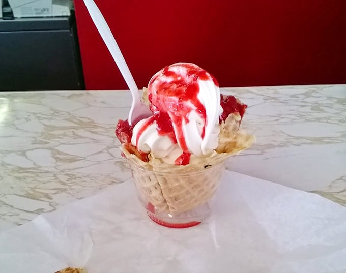 Ice cream and strawberry sauce performing their timeless duet in a waffle cone amphitheater. Some desserts don't need reinvention&mdash;just appreciation.