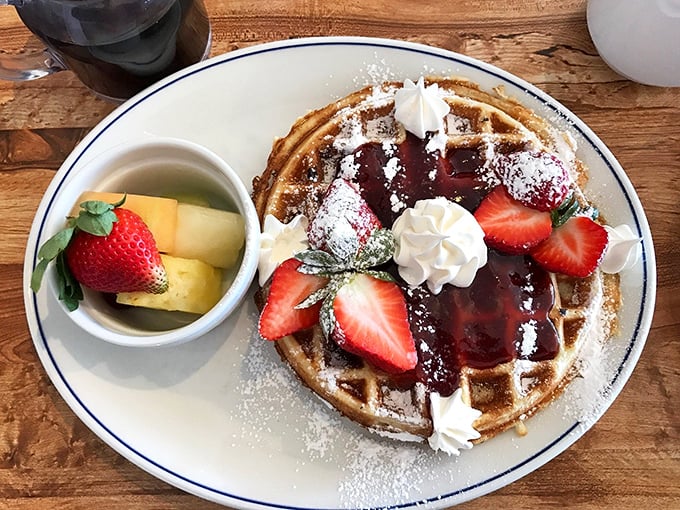 This Belgian waffle, crowned with strawberries and whipped cream, transforms breakfast into dessert without a shred of morning guilt.