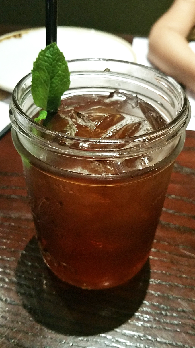 Sweet tea served in a mason jar with fresh mint &ndash; because sometimes the simplest pleasures are the most satisfying. Pure Southern comfort in liquid form.